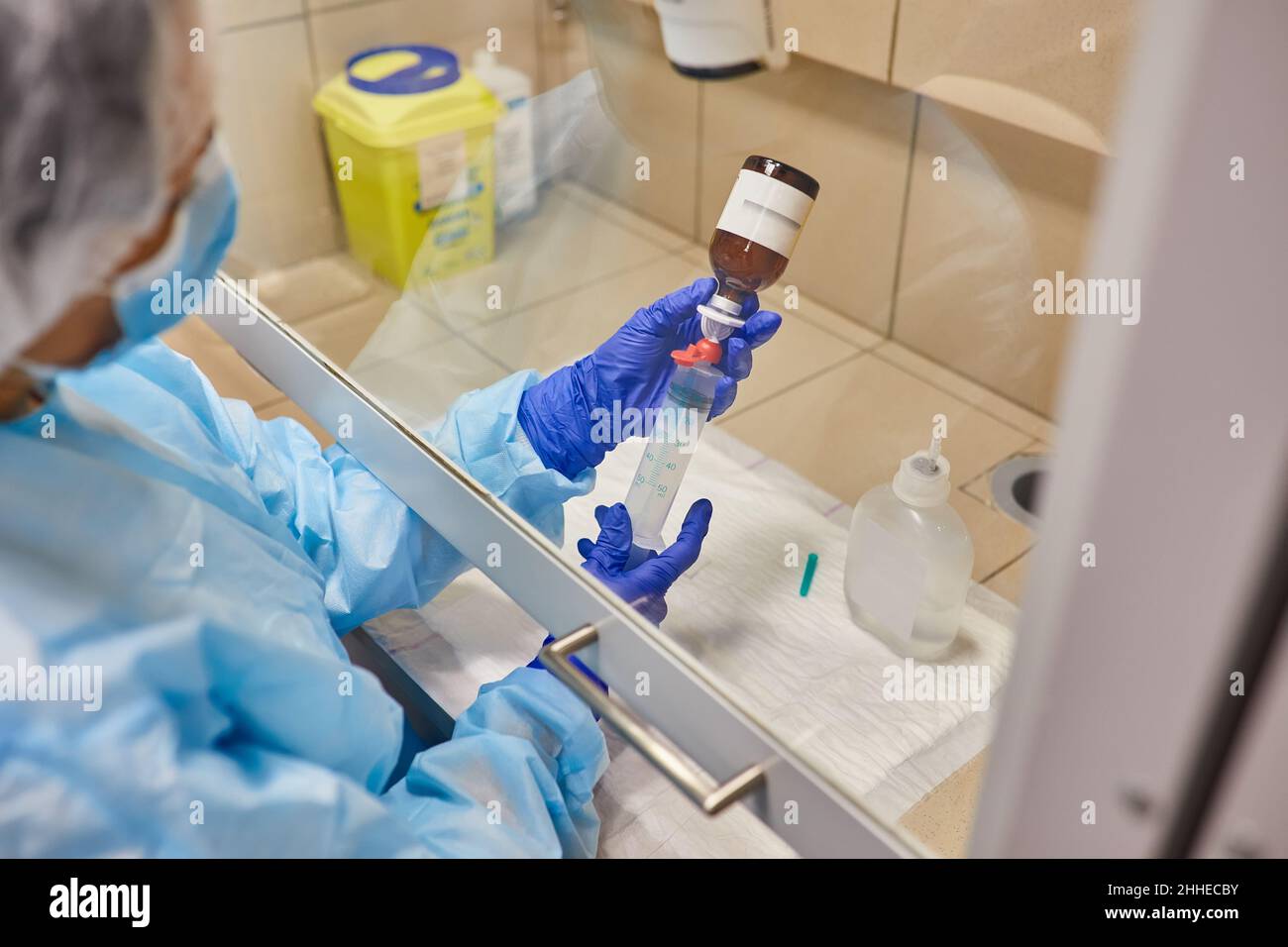 Anesthesiologist Doctors hand inject syringe into mixing normal saline ...