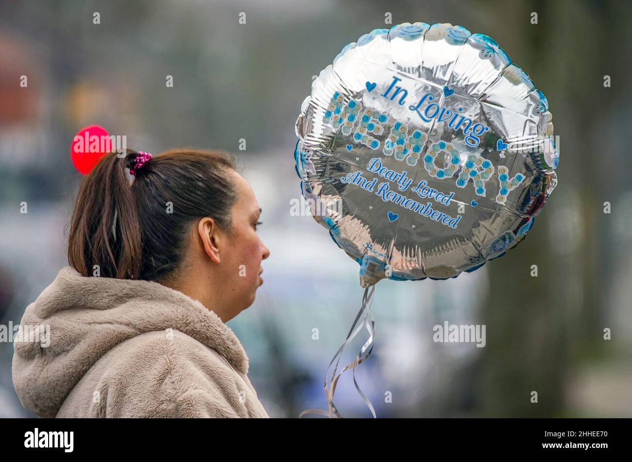 A member of public with flowers and a balloon on Thirlmere Avenue in ...