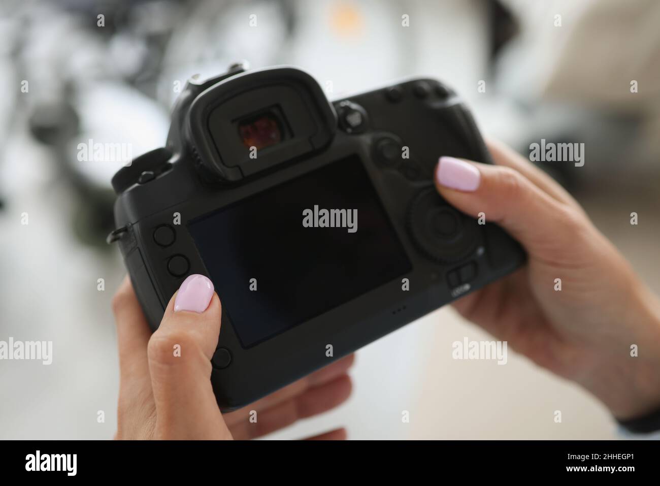 Female hands are holding a black modern camera Stock Photo - Alamy