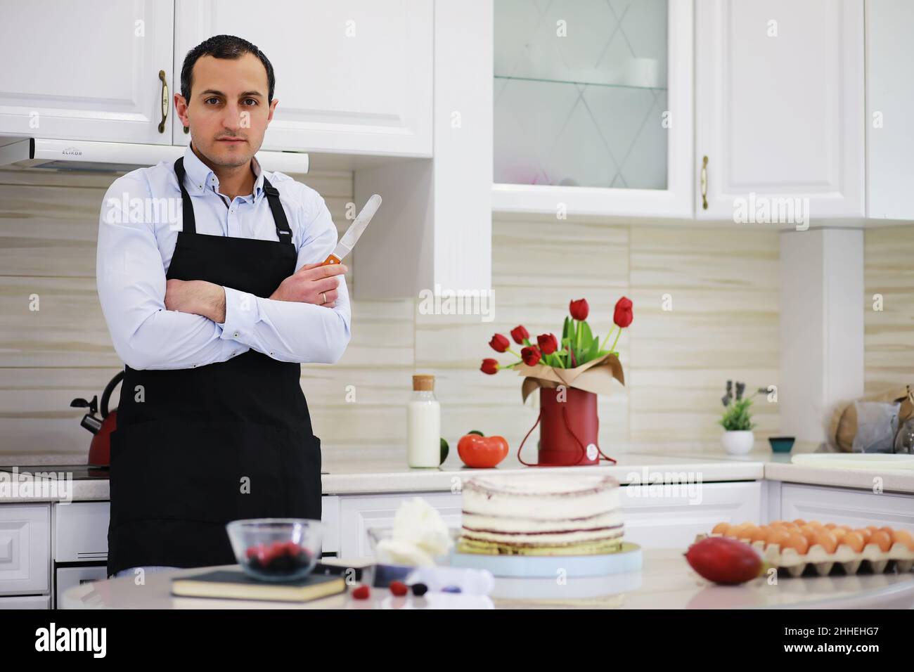 Master pastry chef in front of a desk. Cooking desserts at home. The ...