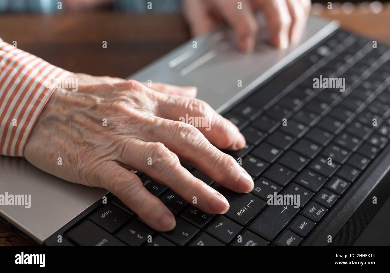 Old woman hands typing on a laptop keyboard Stock Photo - Alamy