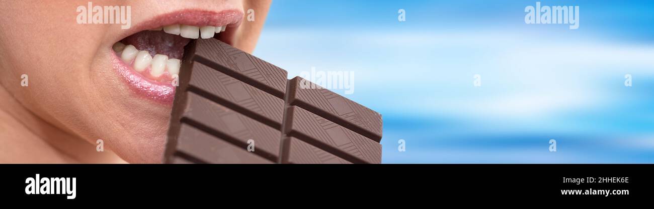 Close up of woman biting in a chocolate bar on blurred background Stock ...