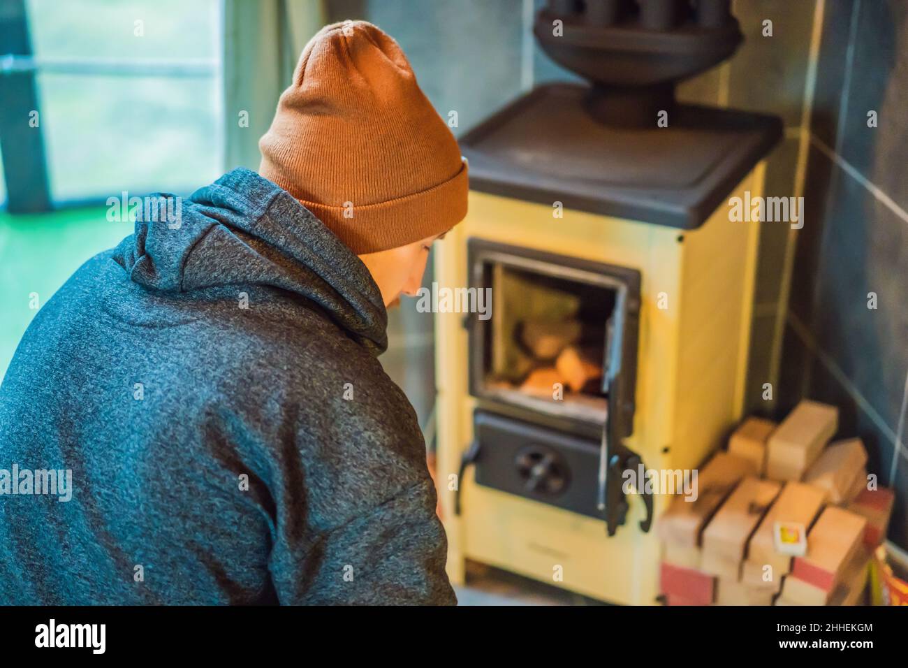 Man making fire in the fireplace. Rest in the mountains in Glamping ...