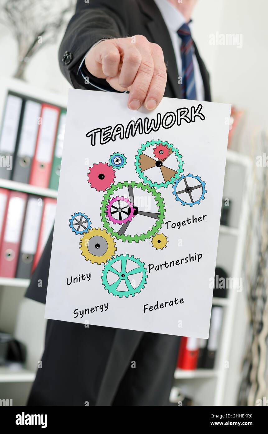 Paper showing teamwork concept held by a businessman Stock Photo - Alamy