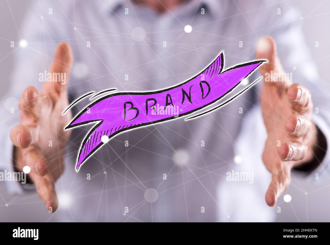Brand concept between hands of a man in background Stock Photo - Alamy