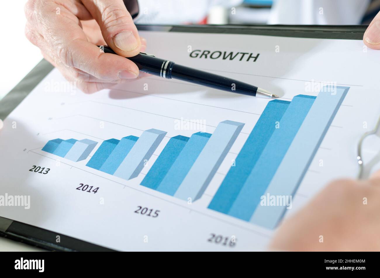Hand pointing a pen on a graph showing growth Stock Photo - Alamy