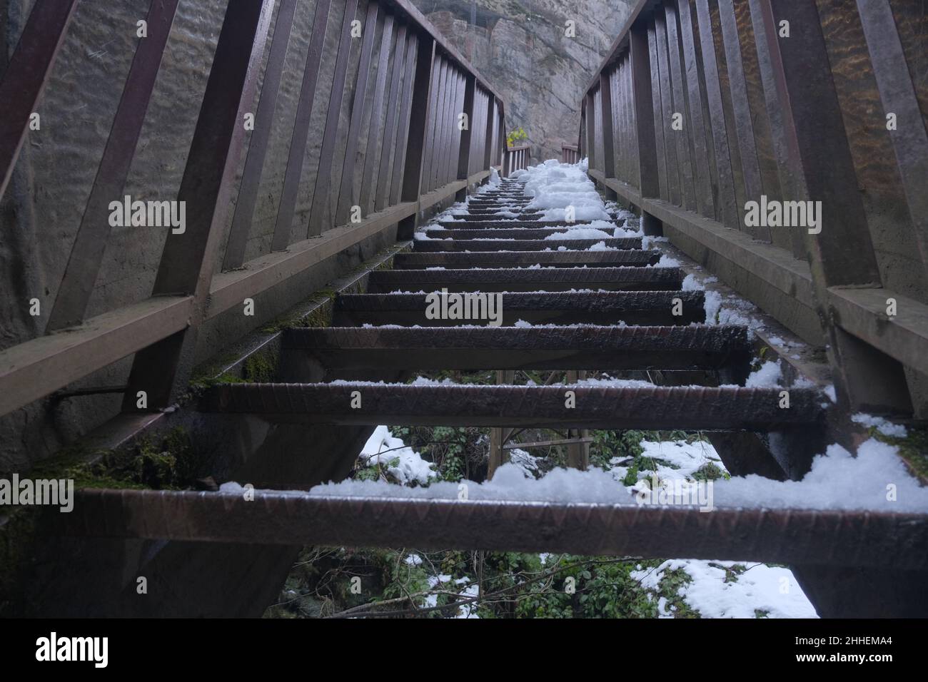 Low angle of wooden bridge, stairs and steps covered by snow. Low angle ...