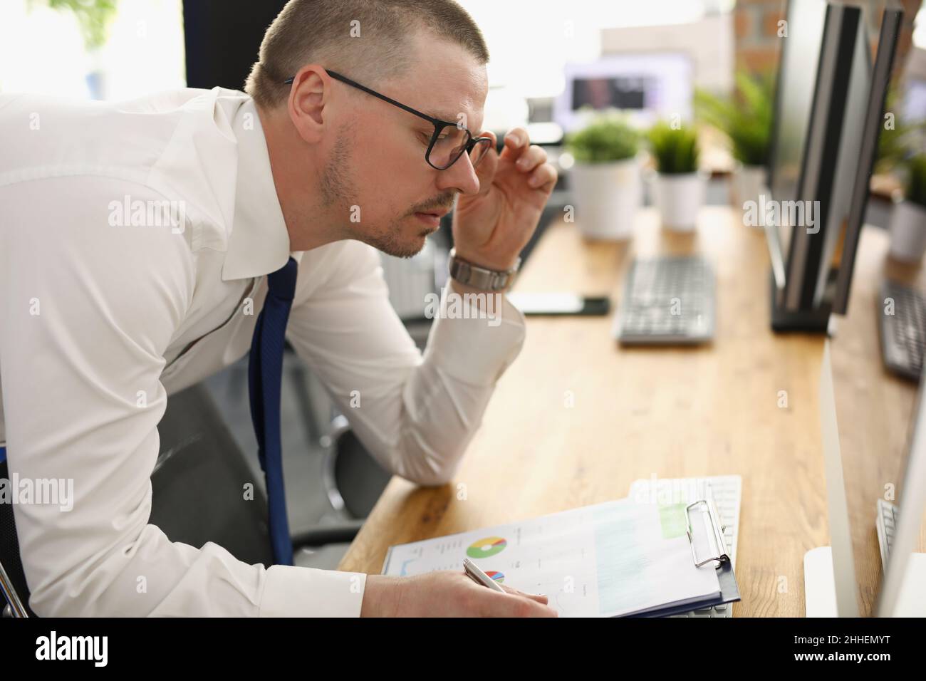 A man in the office is editing a report with a diagram Stock Photo - Alamy