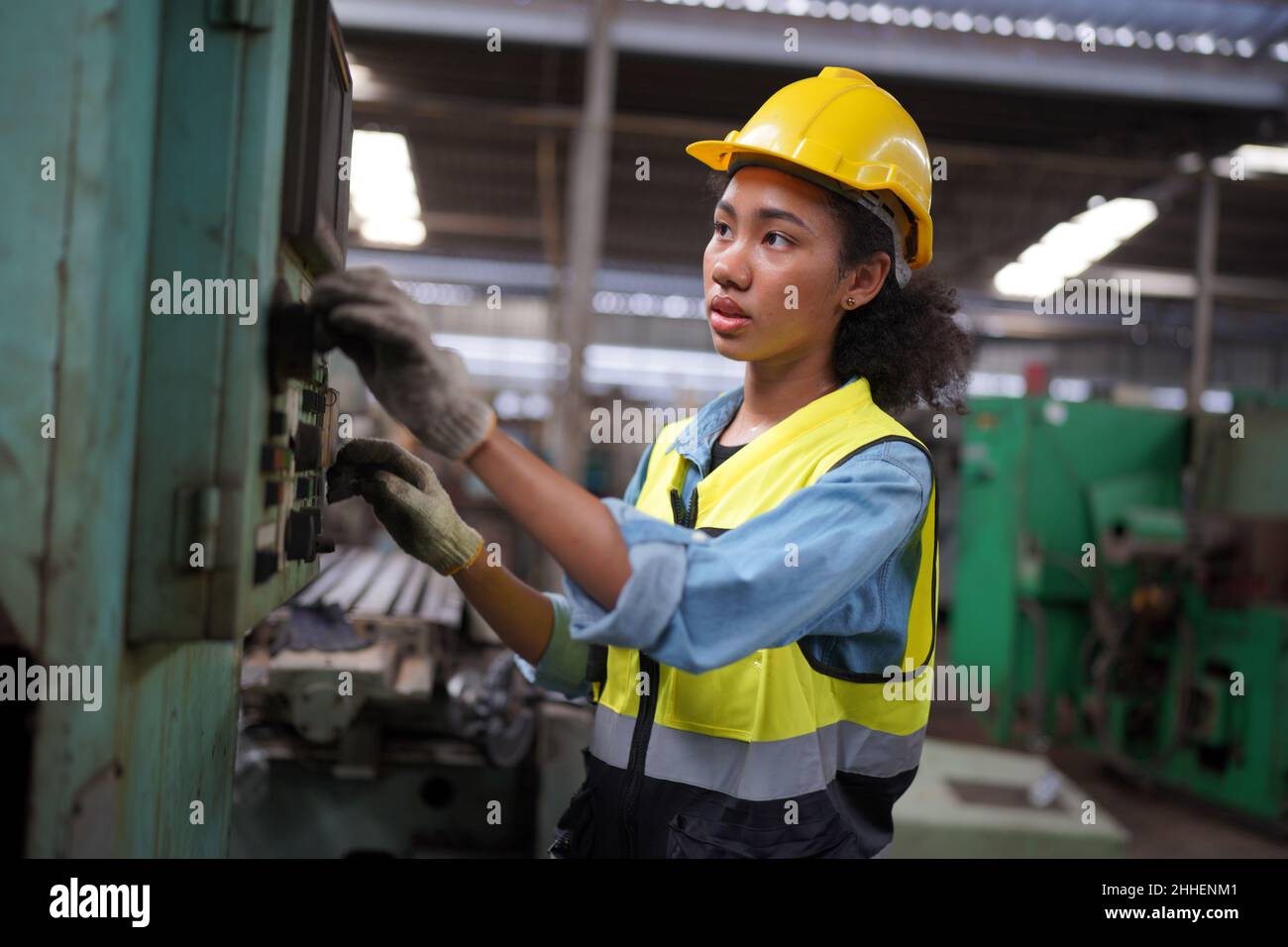 Female apprentice in metal working factory, Portrait of working female ...