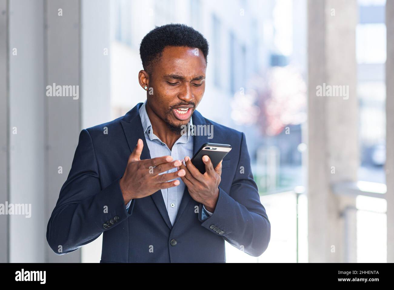 African American male businessman angry talking on mobile phone outside ...