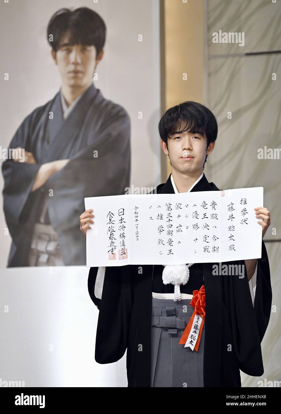 Shogi player Sota Fujii poses with a certificate during a ceremony ...
