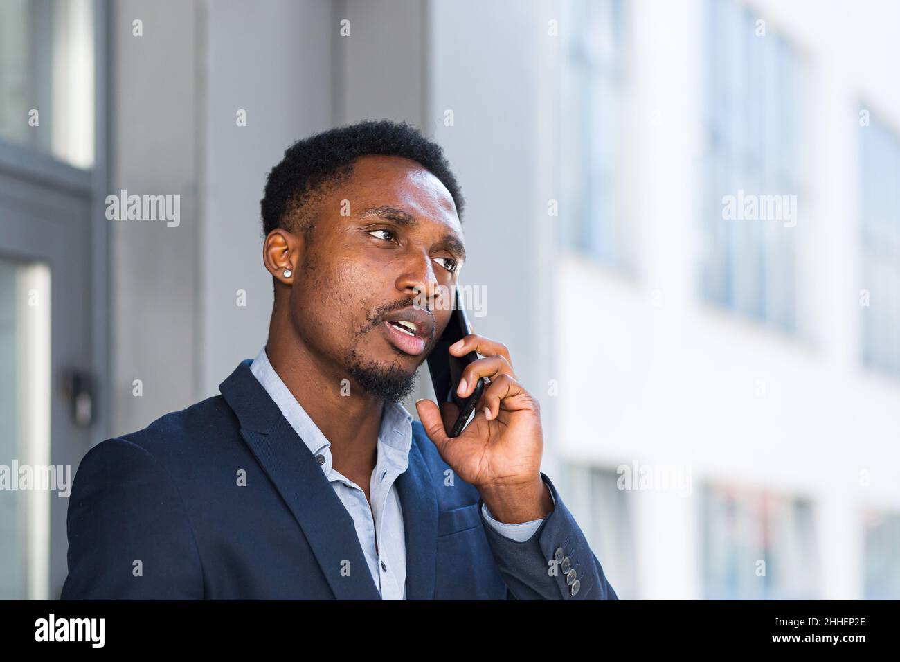 African American male businessman angry talking on mobile phone outside ...