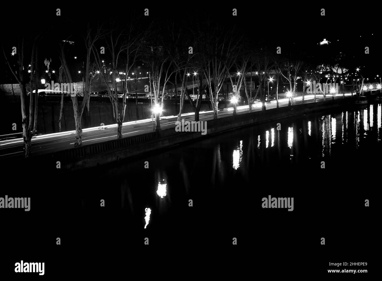 Riverside driveway with night lights reflected on water surface Stock ...