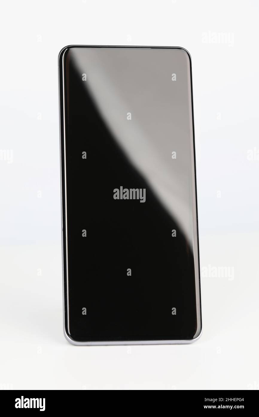 Black smartphone stands upright on a white background Stock Photo - Alamy
