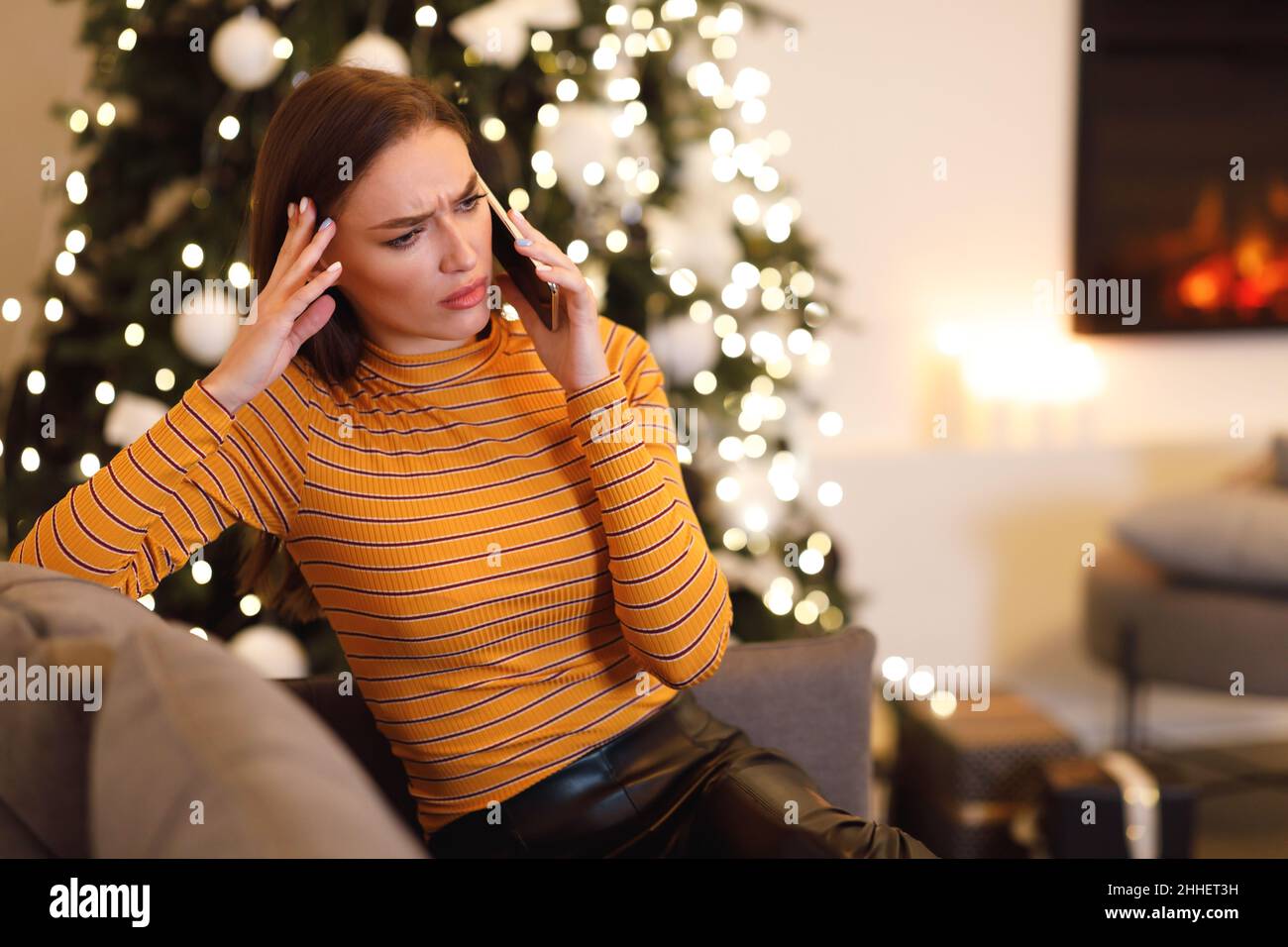 Confused lady talking on cellphone sitting on couch Stock Photo - Alamy