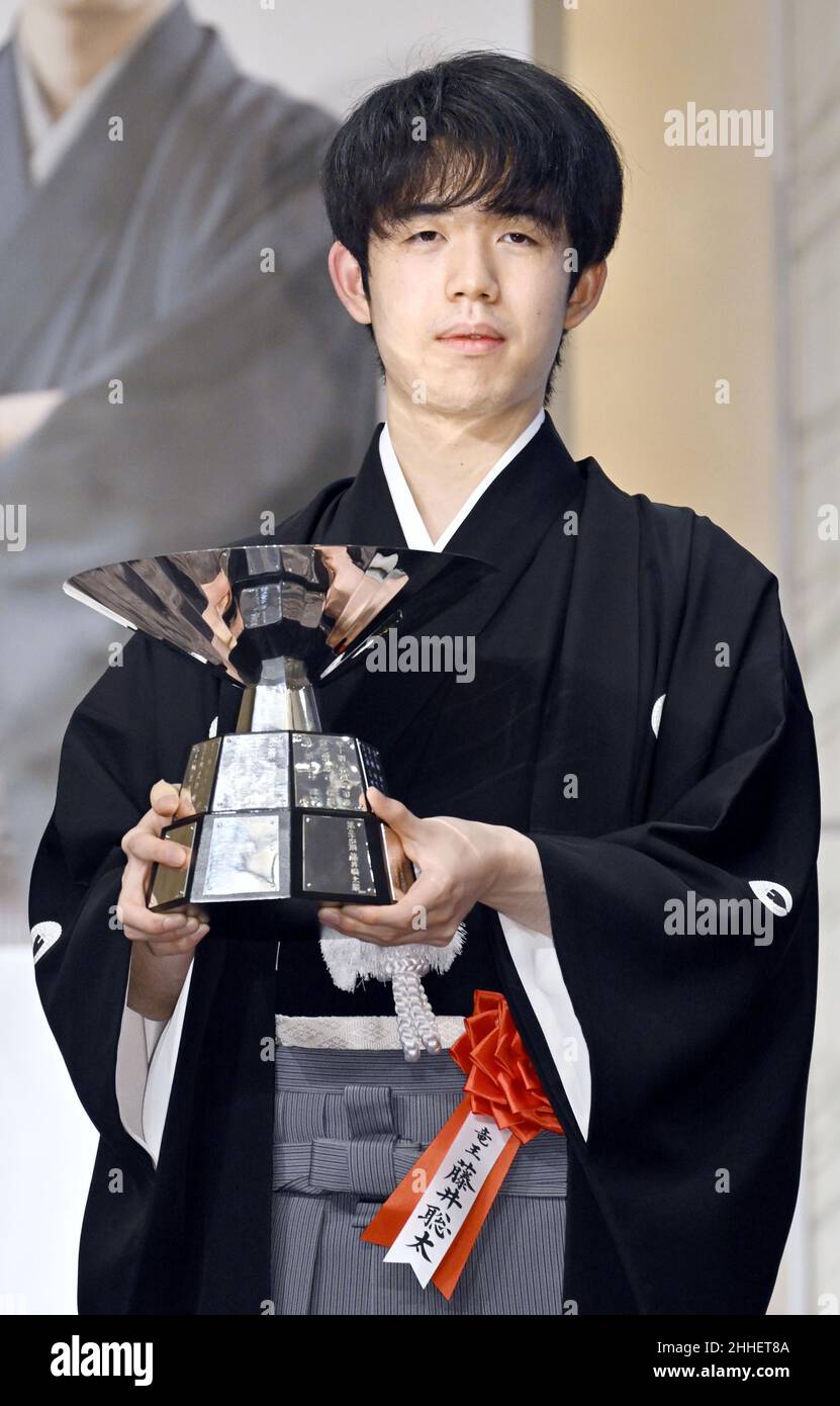 Shogi player Sota Fujii poses with the trophy during a ceremony ...