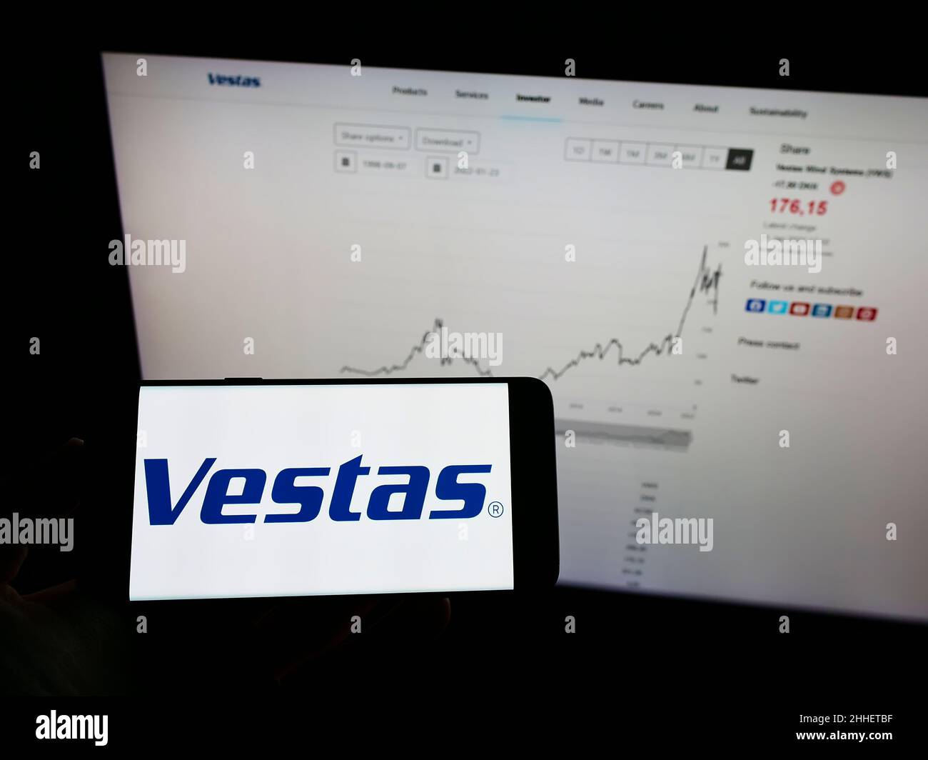 Person holding mobile phone with logo of Danish company Vestas Wind ...