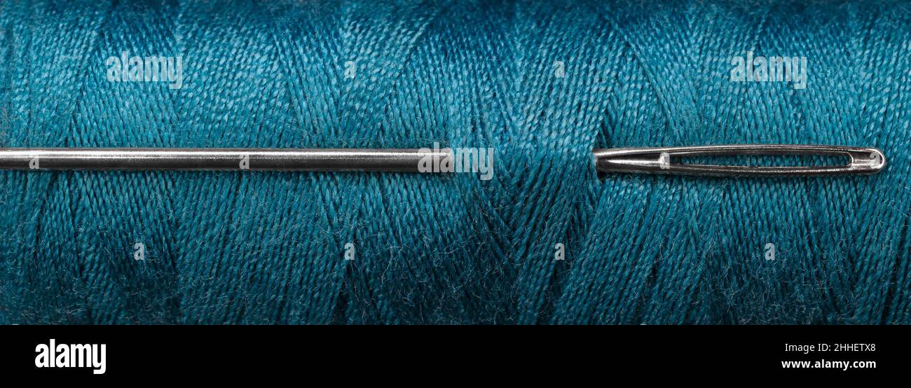 Spool of thread with stuck needle. Macro photography Stock Photo - Alamy