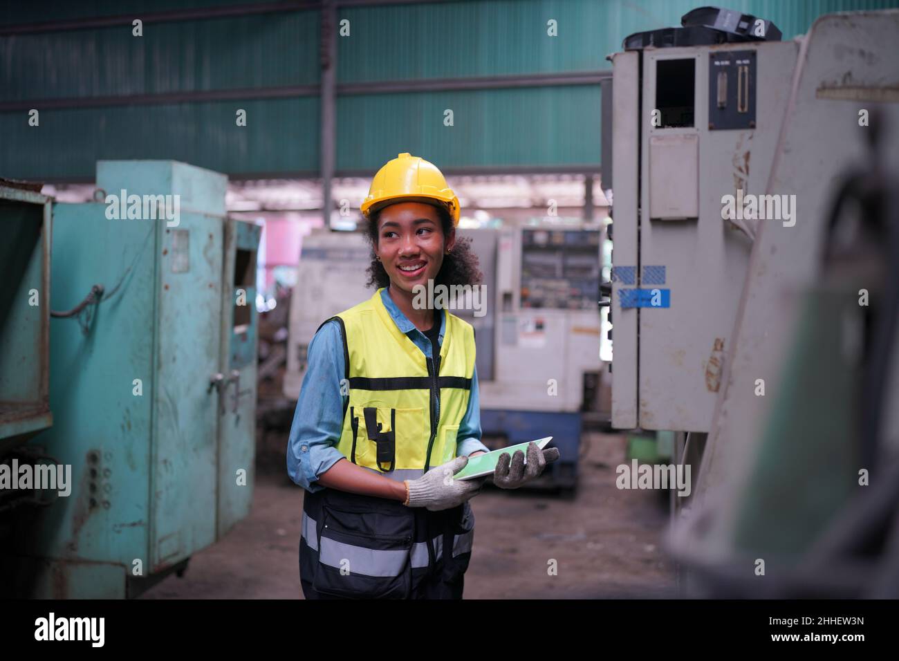 Female apprentice in metal working factory, Portrait of working female ...