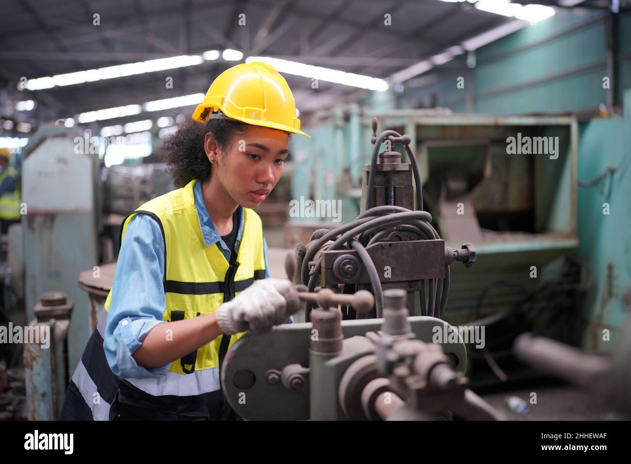 Female apprentice in metal working factory, Portrait of working female ...