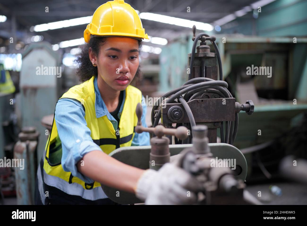 Female apprentice in metal working factory, Portrait of working female ...
