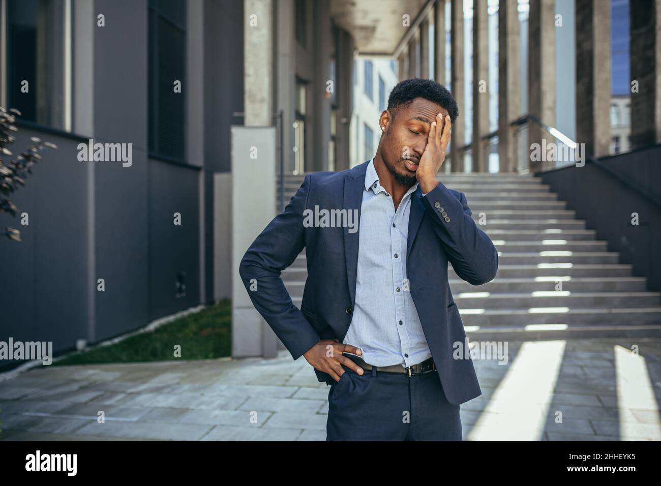 exhausted young African American business man office worker stand ...