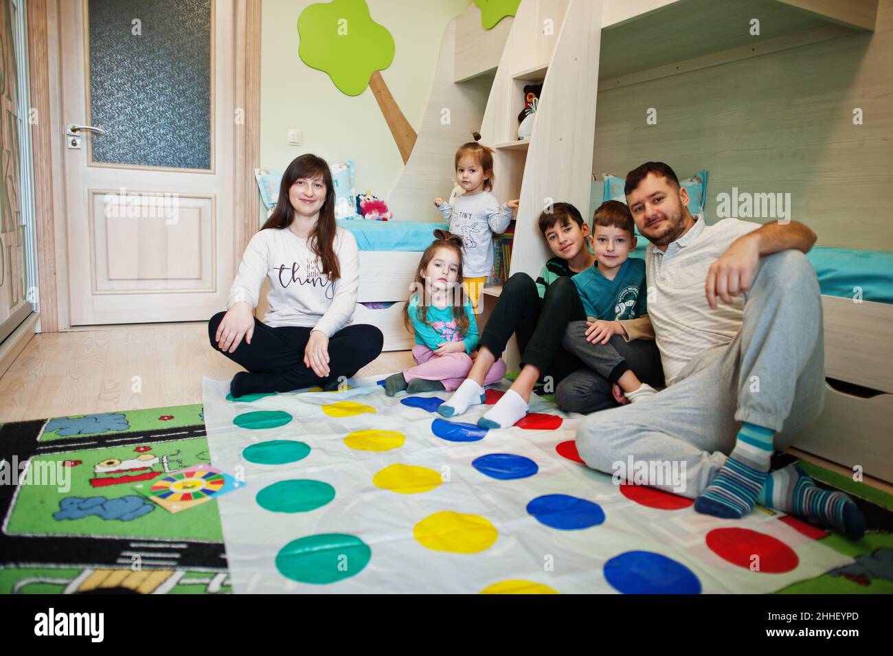 Happy big family having fun together,four kids playing twister game at ...