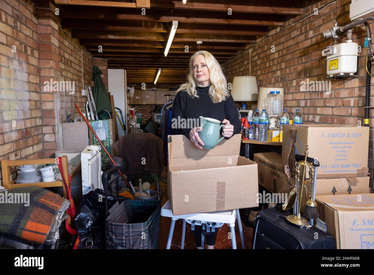Senior lady with some of her belongings before moving home, England ...