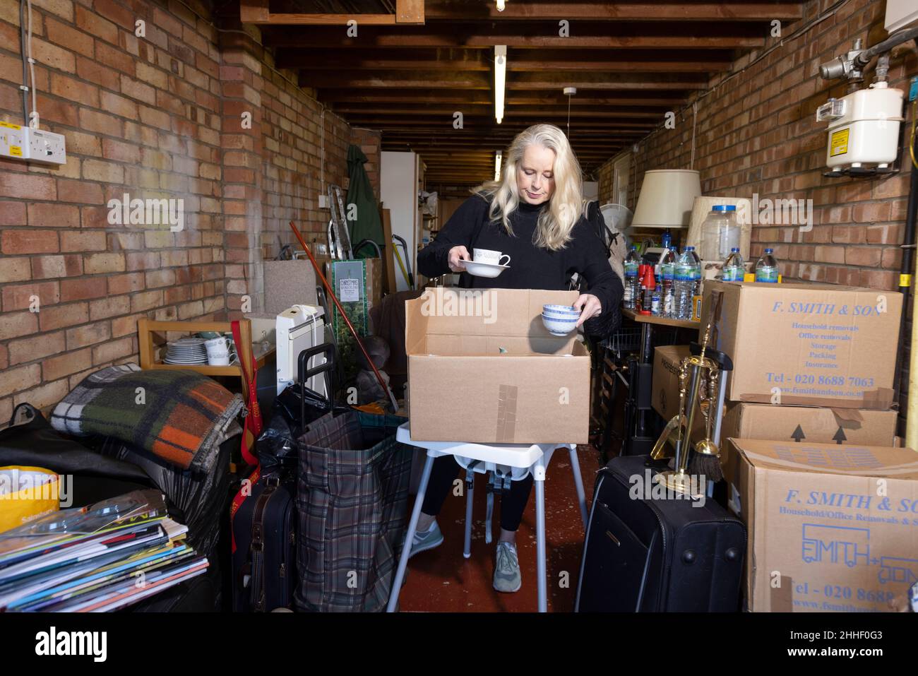 Senior lady with some of her belongings before moving home, England ...