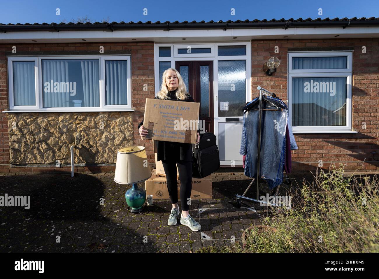 Senior lady with some of her belongings before moving home, England ...