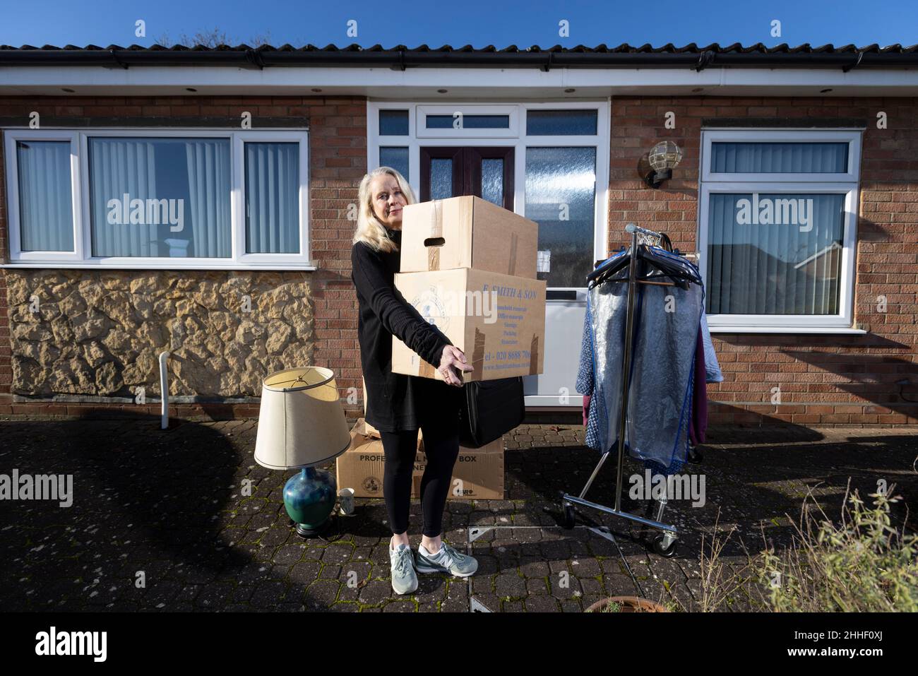 Senior lady with some of her belongings before moving home, England ...