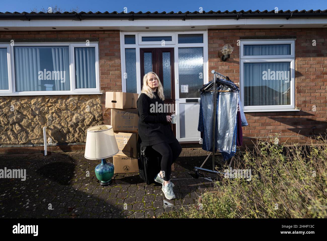 Senior lady with some of her belongings before moving home, England ...