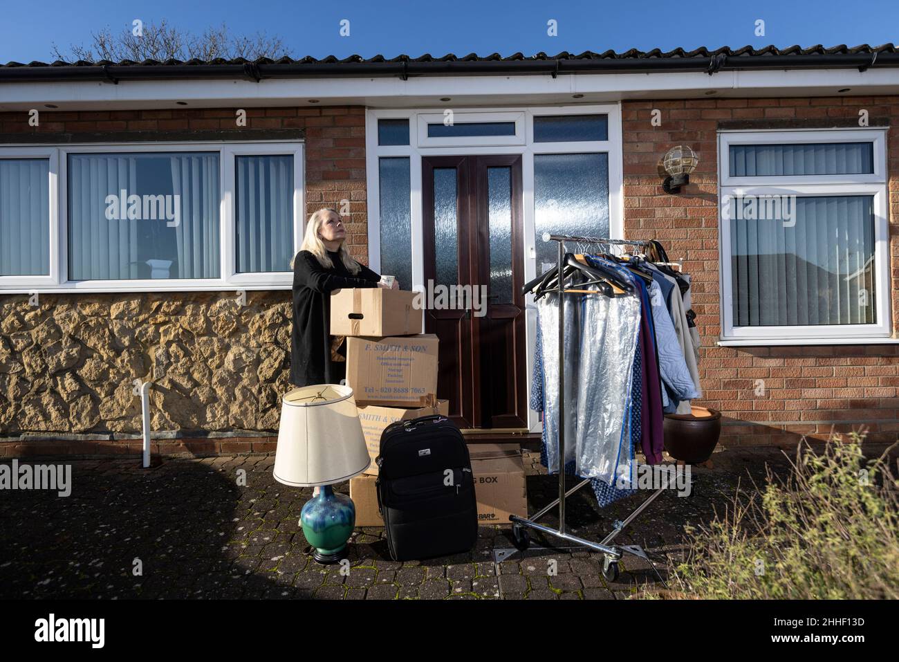 Senior lady with some of her belongings before moving home, England ...