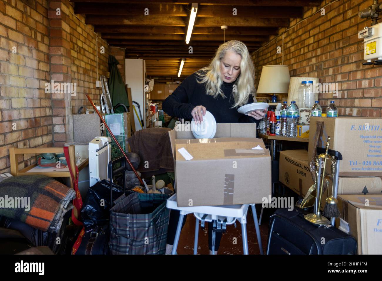 Senior lady with some of her belongings before moving home, England ...