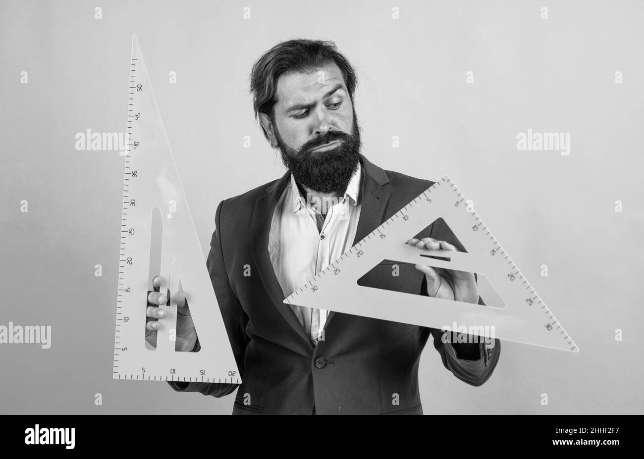 mature bearded man in business suit hold math triangle ruler, graphics ...