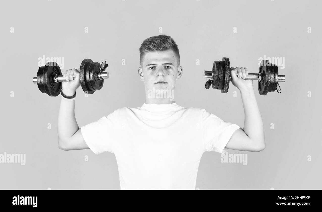 teen boy training biceps muscles with barbell, sport Stock Photo - Alamy