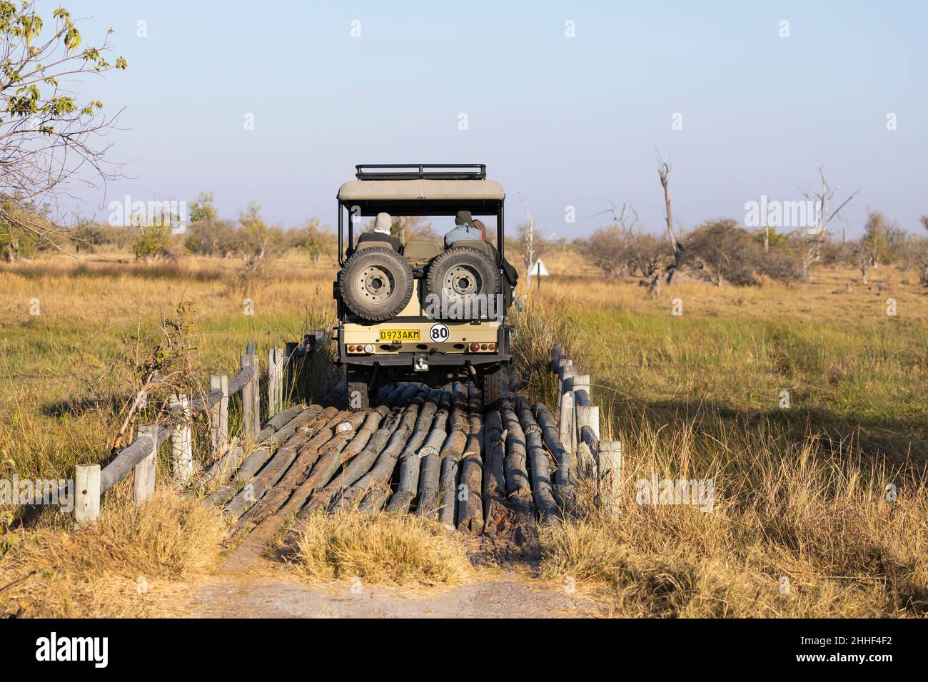A safari vehicle crossing a bridge in the landscape of swamps and ...