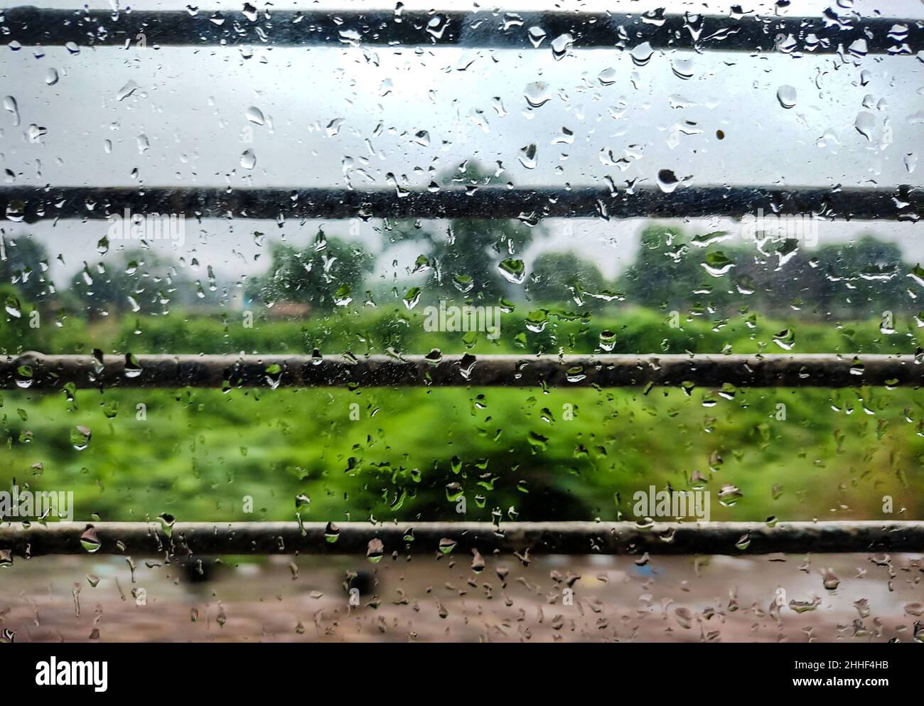 A Closeup image of water droplets on the window of running train during ...