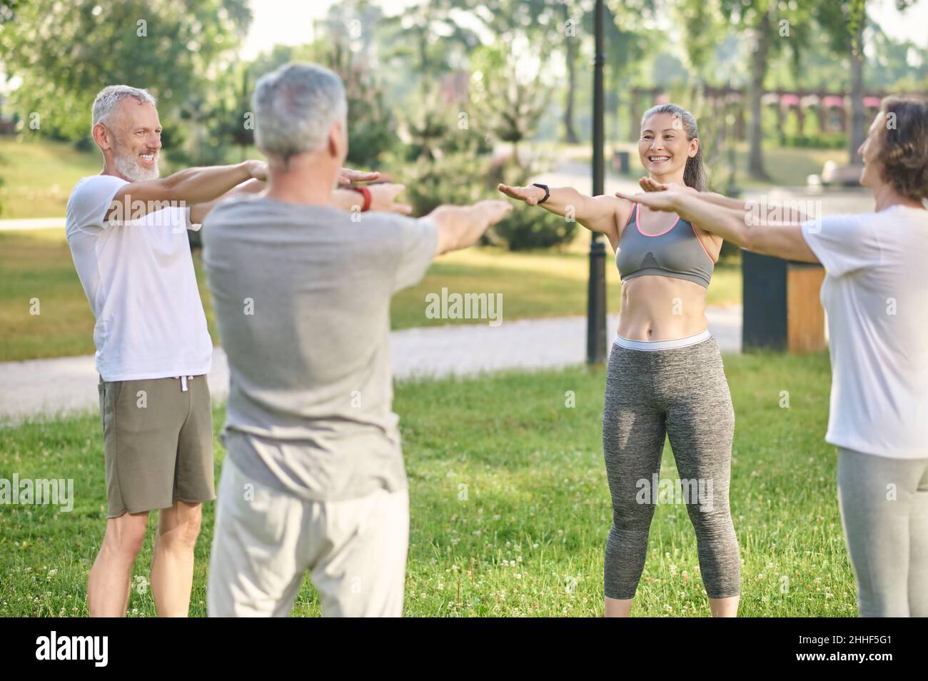 Group of people doing morning exercises in the park Stock Photo - Alamy