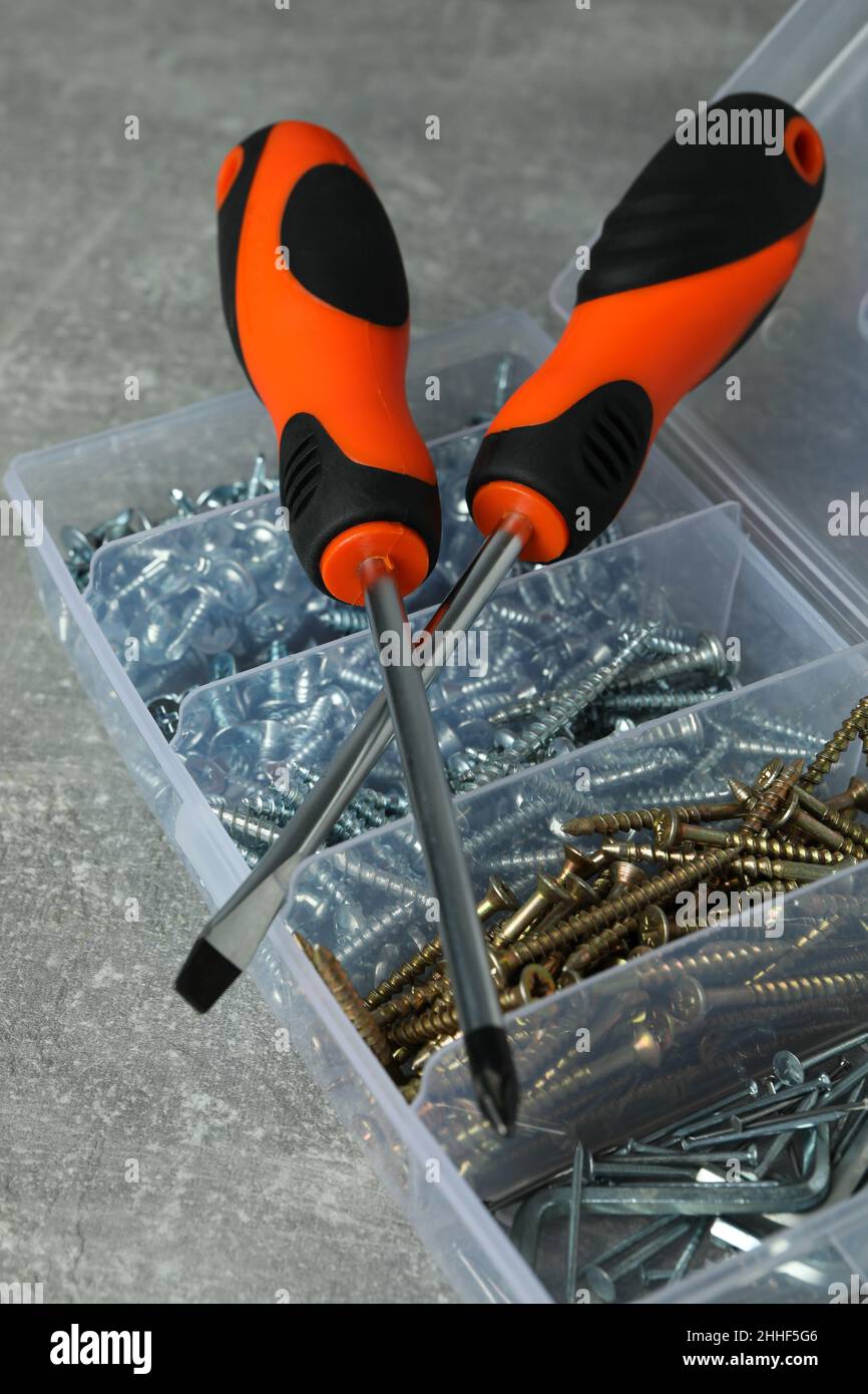 Box with screws and screwdrivers on gray textured background Stock ...