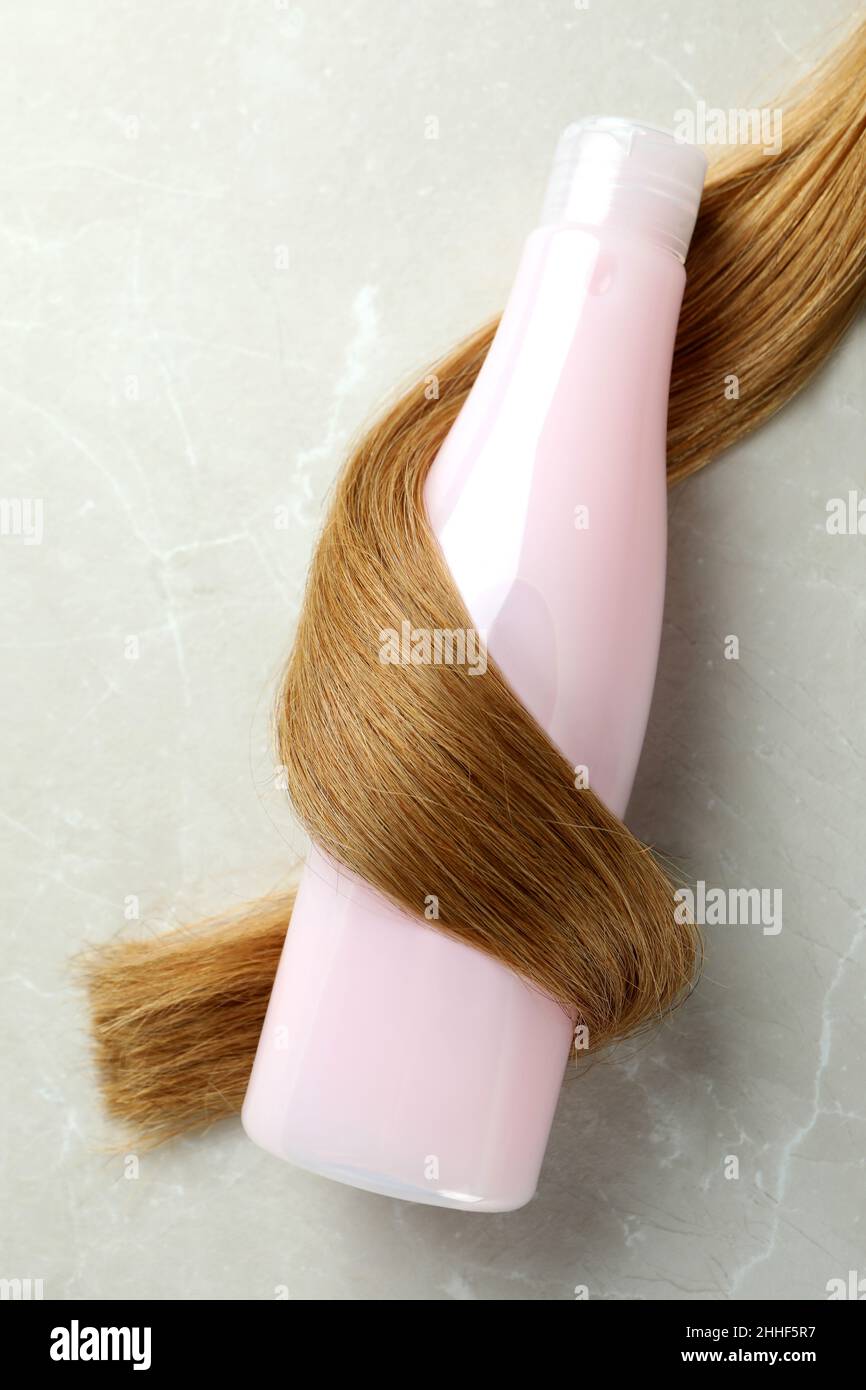 A lock of female hair with shampoo bottle Stock Photo - Alamy
