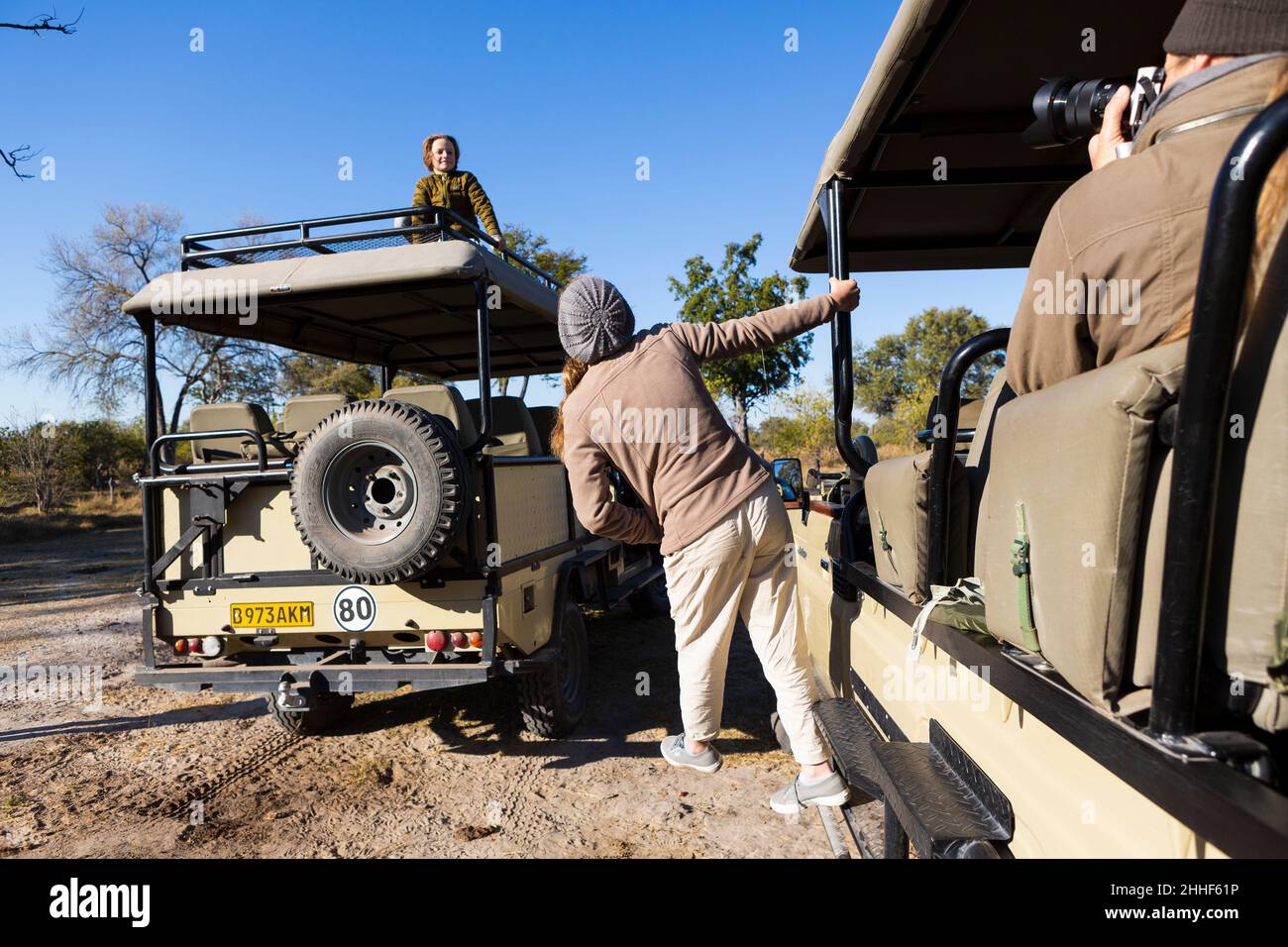 Teenage girl leaning out of a safari jeep, a boy on the roof of a ...