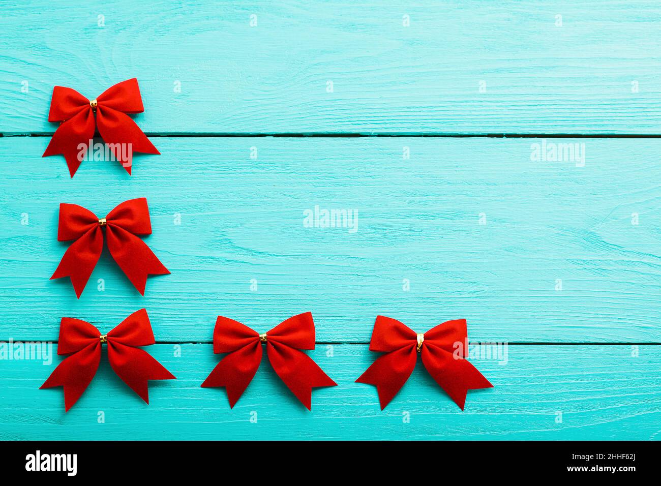 Frame of red bows with winter accessories on blue wooden background Stock Photo - Alamy