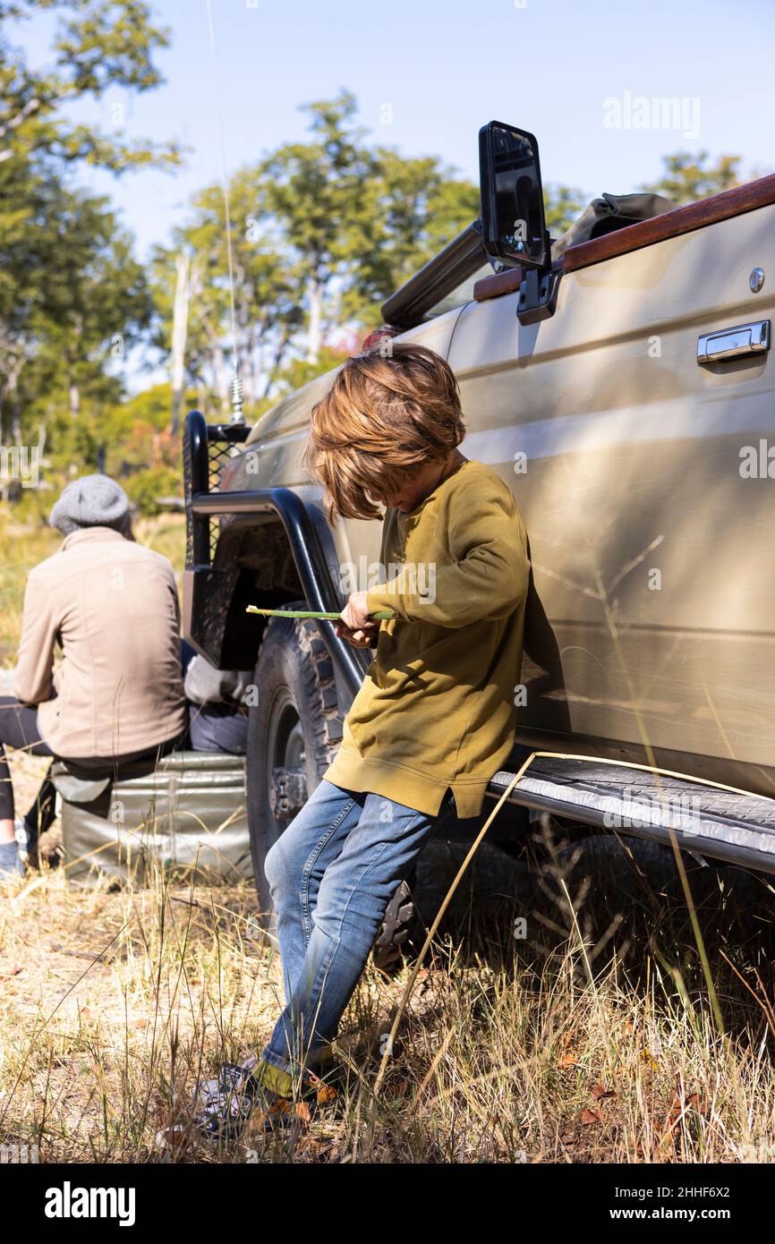 A boy by a safari jeep playing with a toy Stock Photo - Alamy
