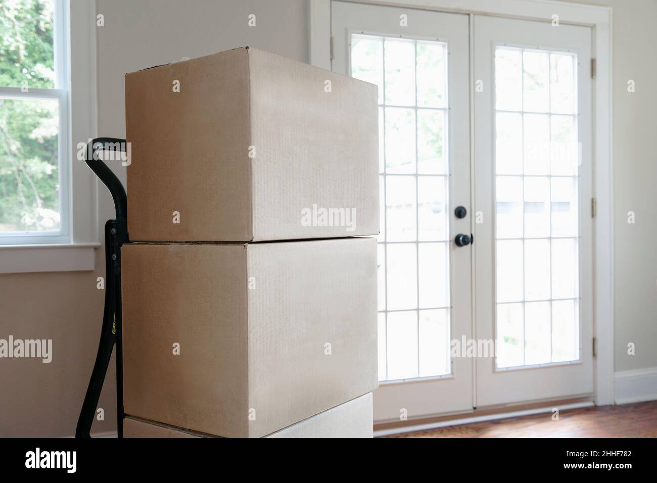 Moving house, relocation, cardboard boxes piled up in an empty house ... Moving house, relocation, cardboard boxes piled up in an empty house ...