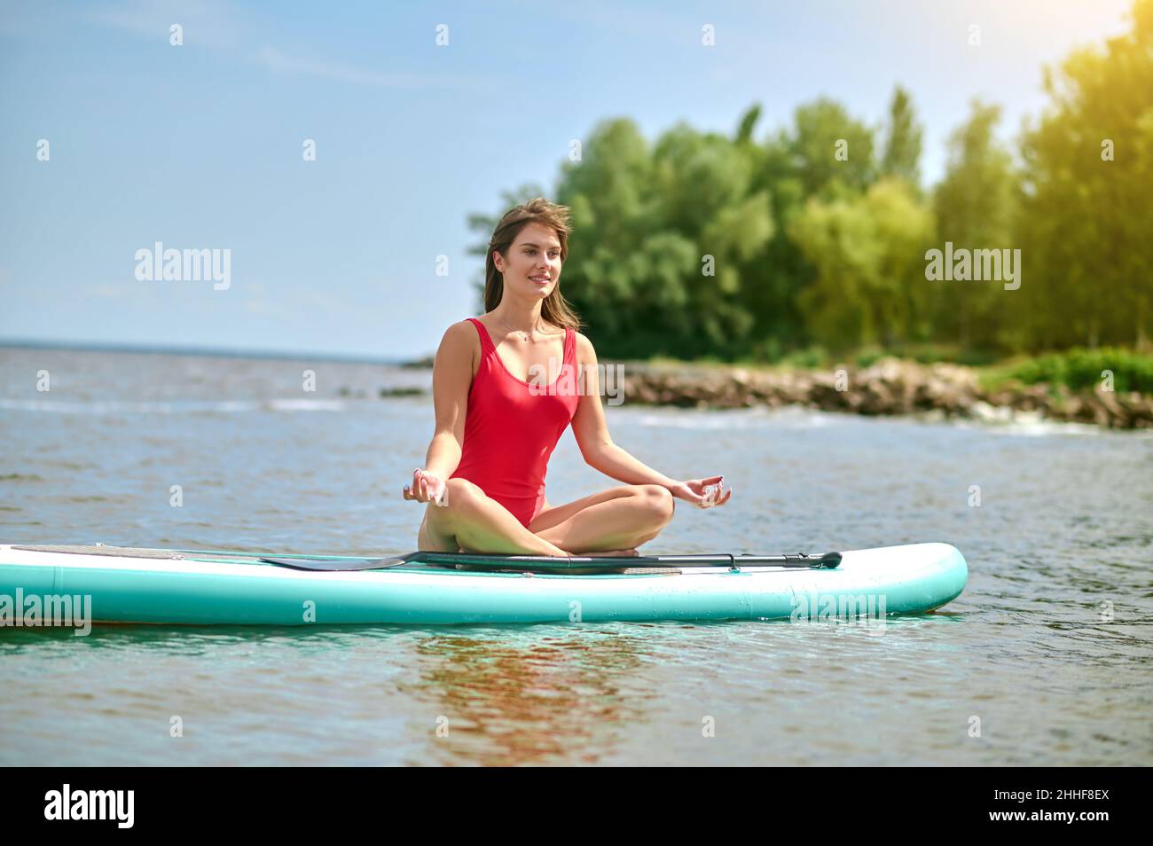 A woman in a red swimming suit kayaking and feeling peaceful Stock ...