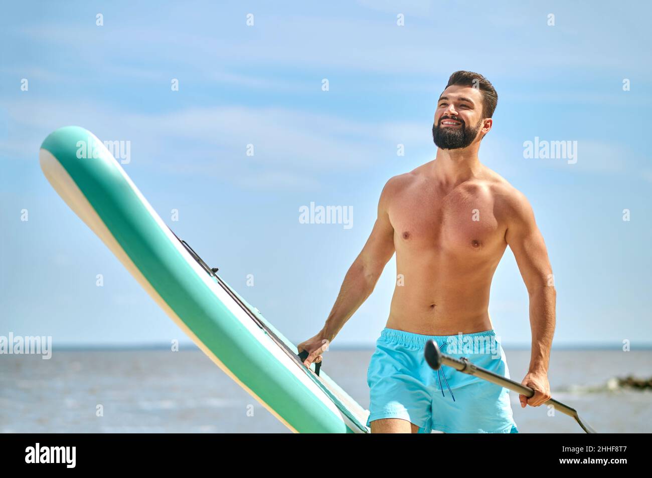 A handsome dark-haired man with a kayak on a beach Stock Photo - Alamy