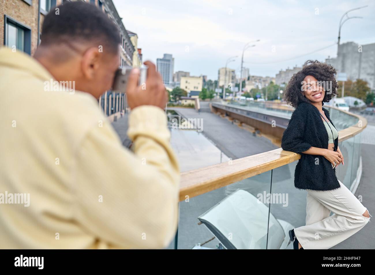 Man photographing woman posing on bridge Stock Photo - Alamy