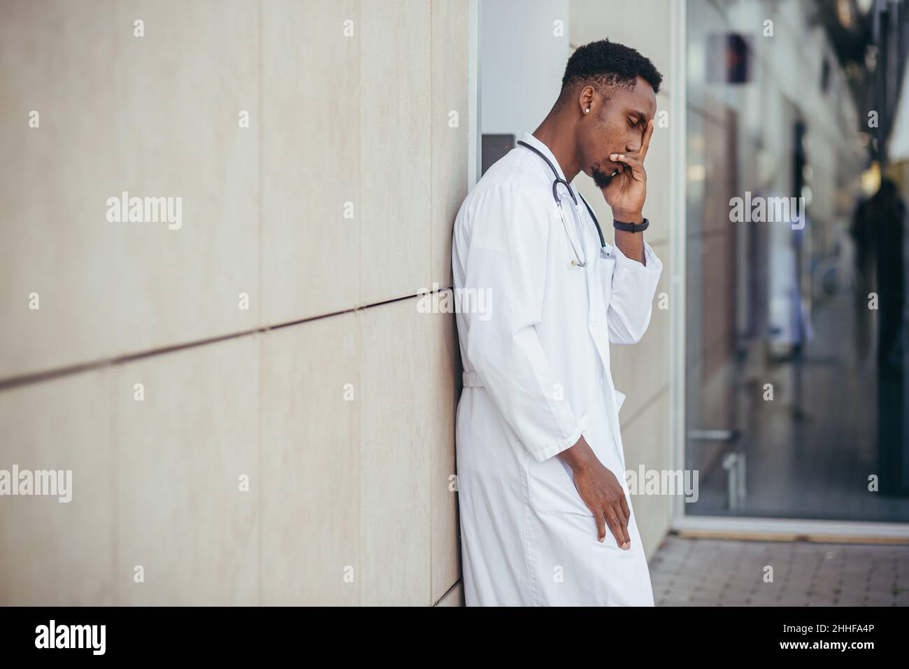 male doctor at the clinic holding his head has health problems and ...
