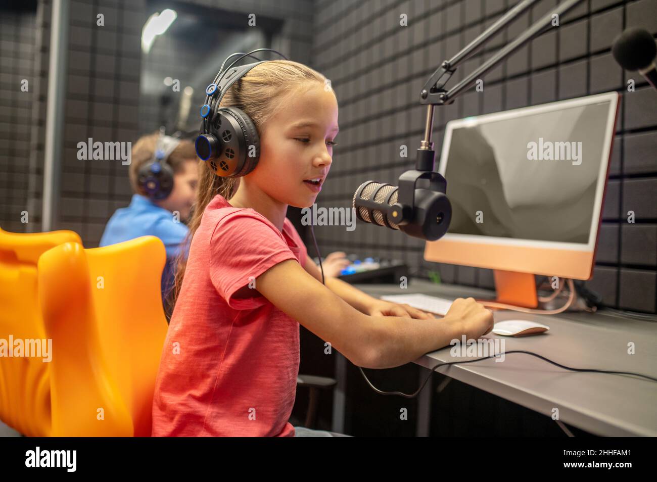 Concentrated girl in the headphones speaking into the microphone Stock ...